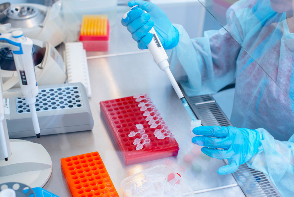 Dna test in the lab. a laboratory technician with a dispenser in his ...